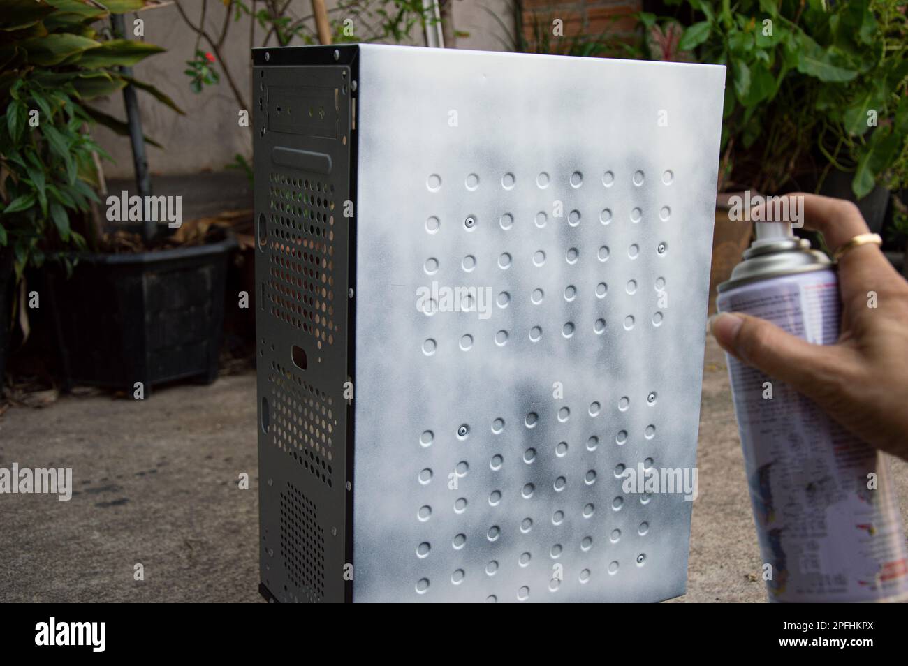 side view Worker spraying white paint Stock Photo - Alamy