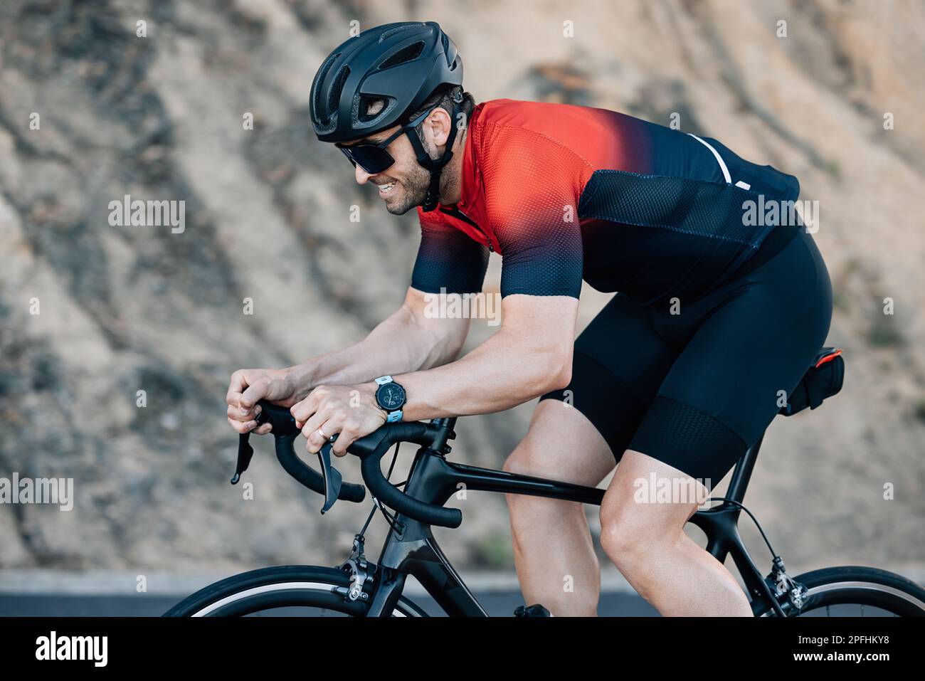 Cyclist doing intense ride outdoors. Professional male road bike rider ...