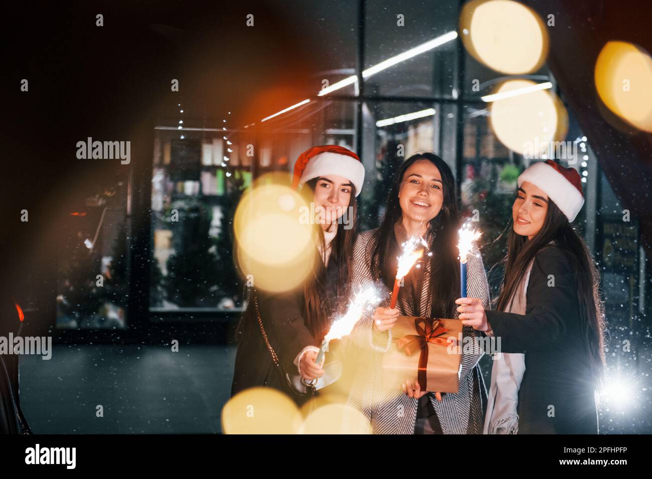 Little fireworks, Bengal lights. Three cheerful women spends Christmas holidays together ...
