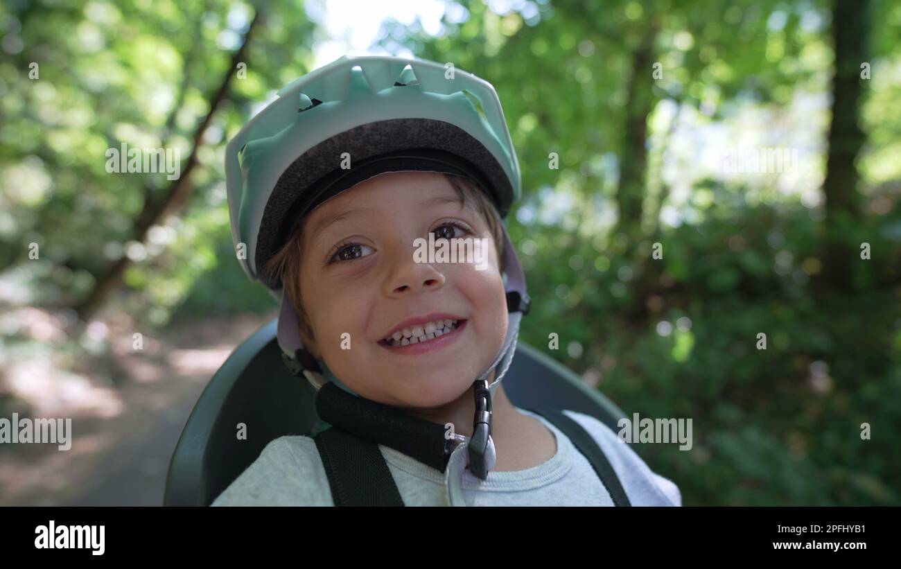 Small boy wearing protective helmet smiling at camera. Child seated in ...