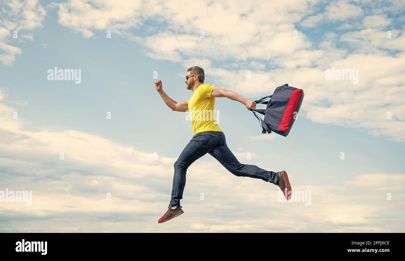 Active man running with sporty bag midair sky background, sport Stock ...
