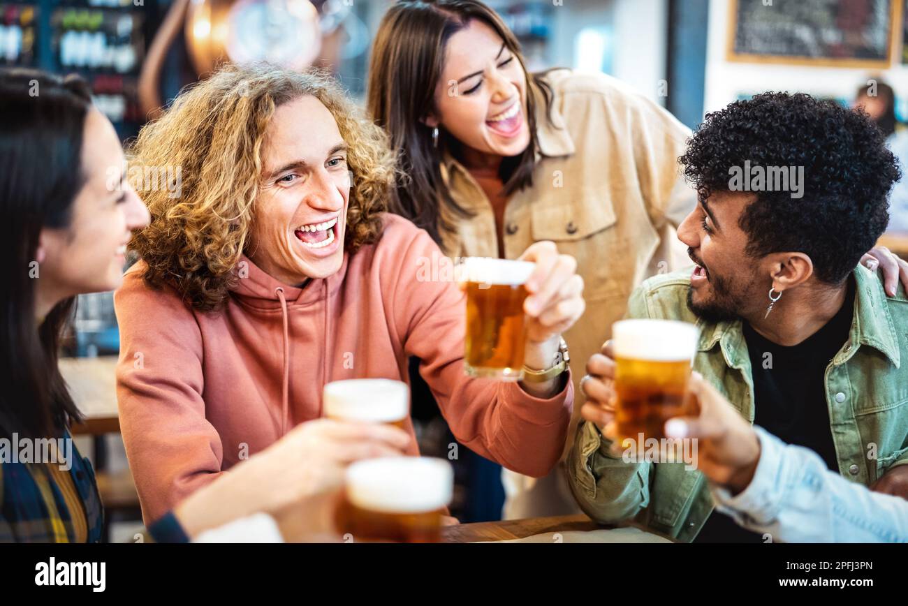 Multi racial hipster friends drinking and toasting beer at brewery bar ...
