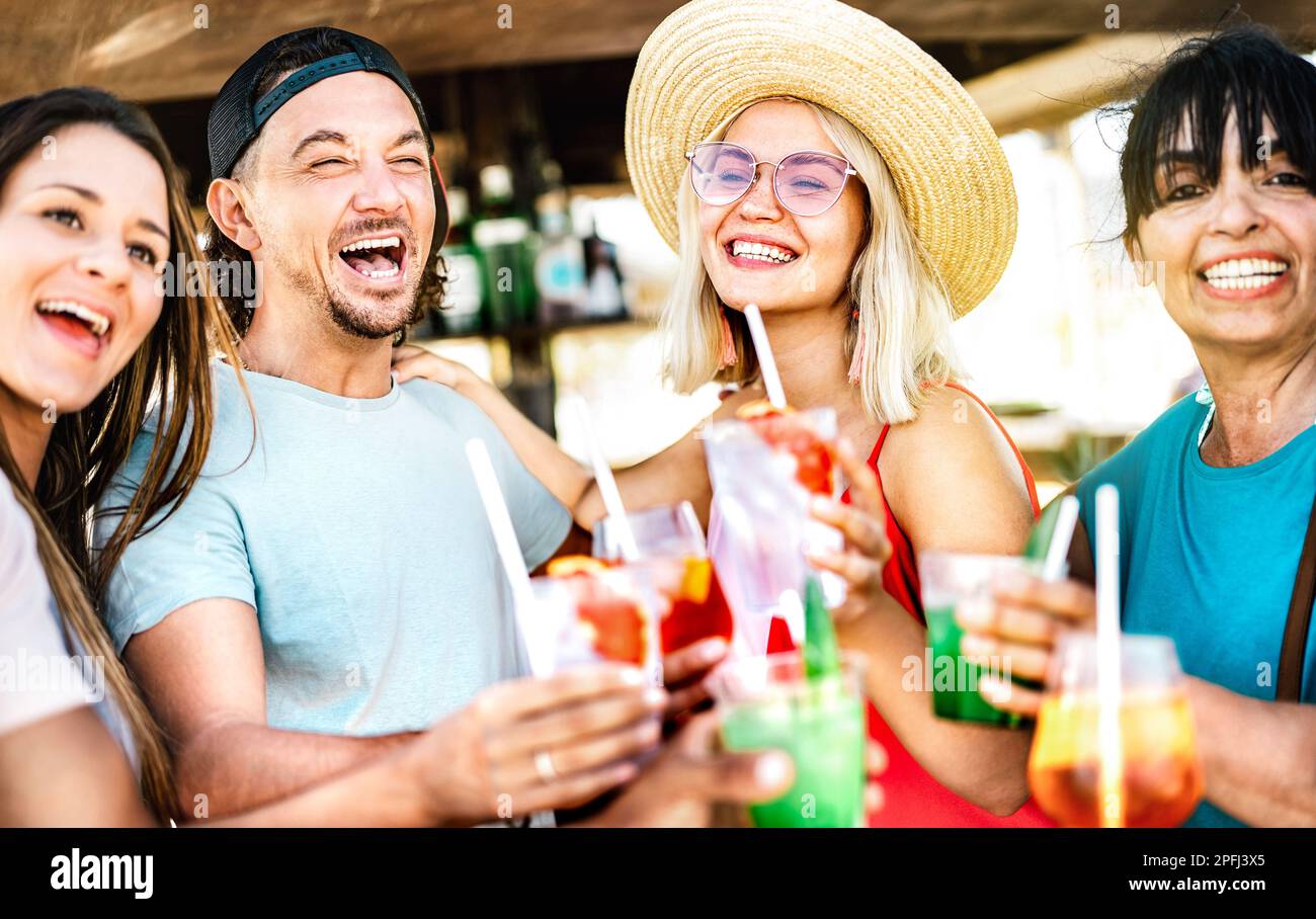 Mixed age range family friends toasting cocktails at chiringuito beach ...