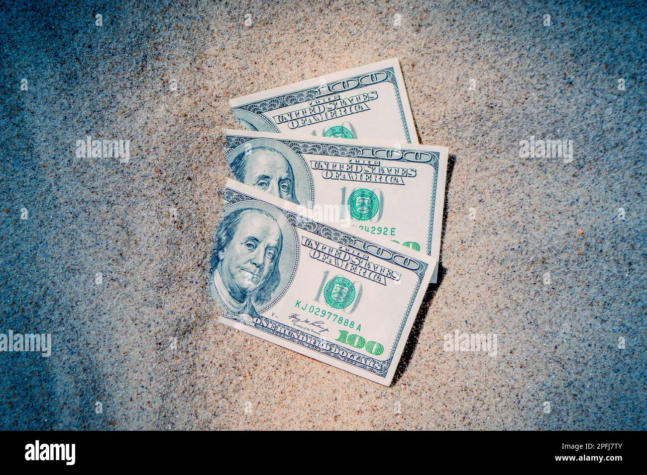 Money dolars half covered with sand lie on beach close-up. Dollar bills ...