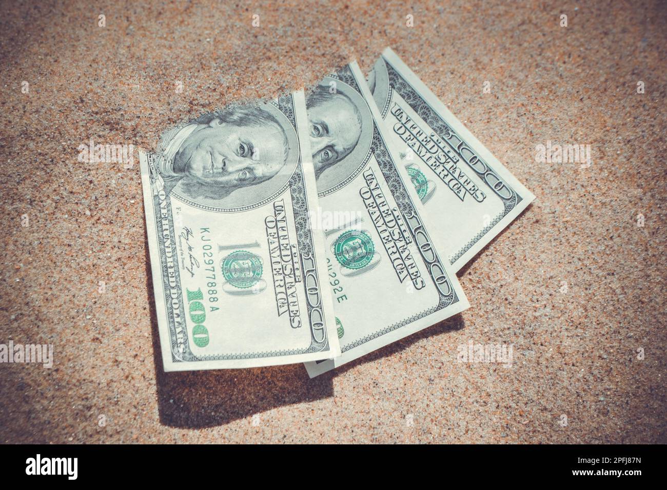Money dolars half covered with sand lie on beach close-up. Dollar bills ...
