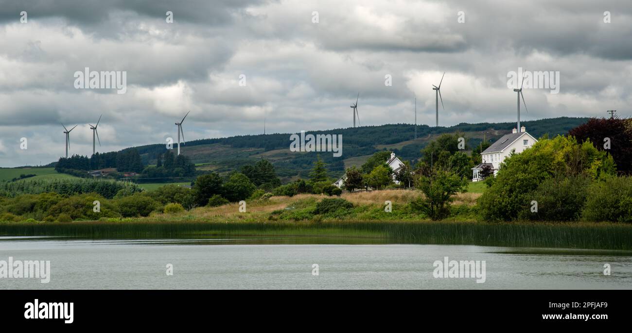 Ireland countryside with white cottage houses and windmills for wind ...