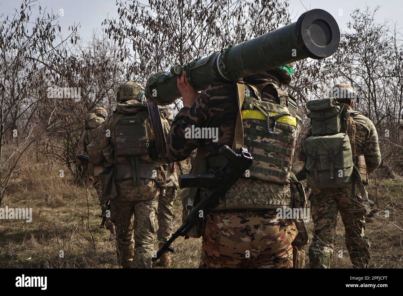 Ukrainian soldiers walk carrying an anti-tank missile systems 'Stugna ...