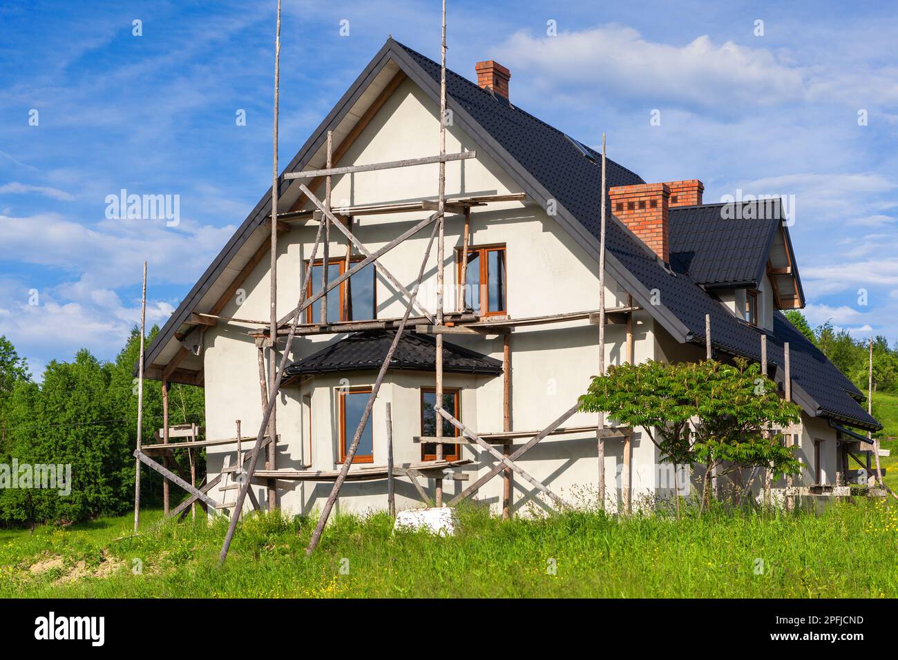 Traditional house under construction in spring landscape Stock Photo ...