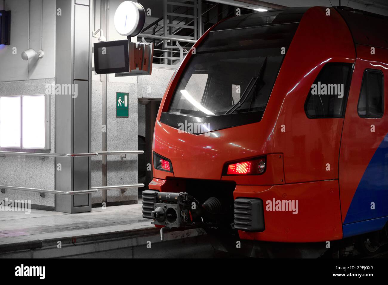 Red and blue passenger train at the platform of railway station ...
