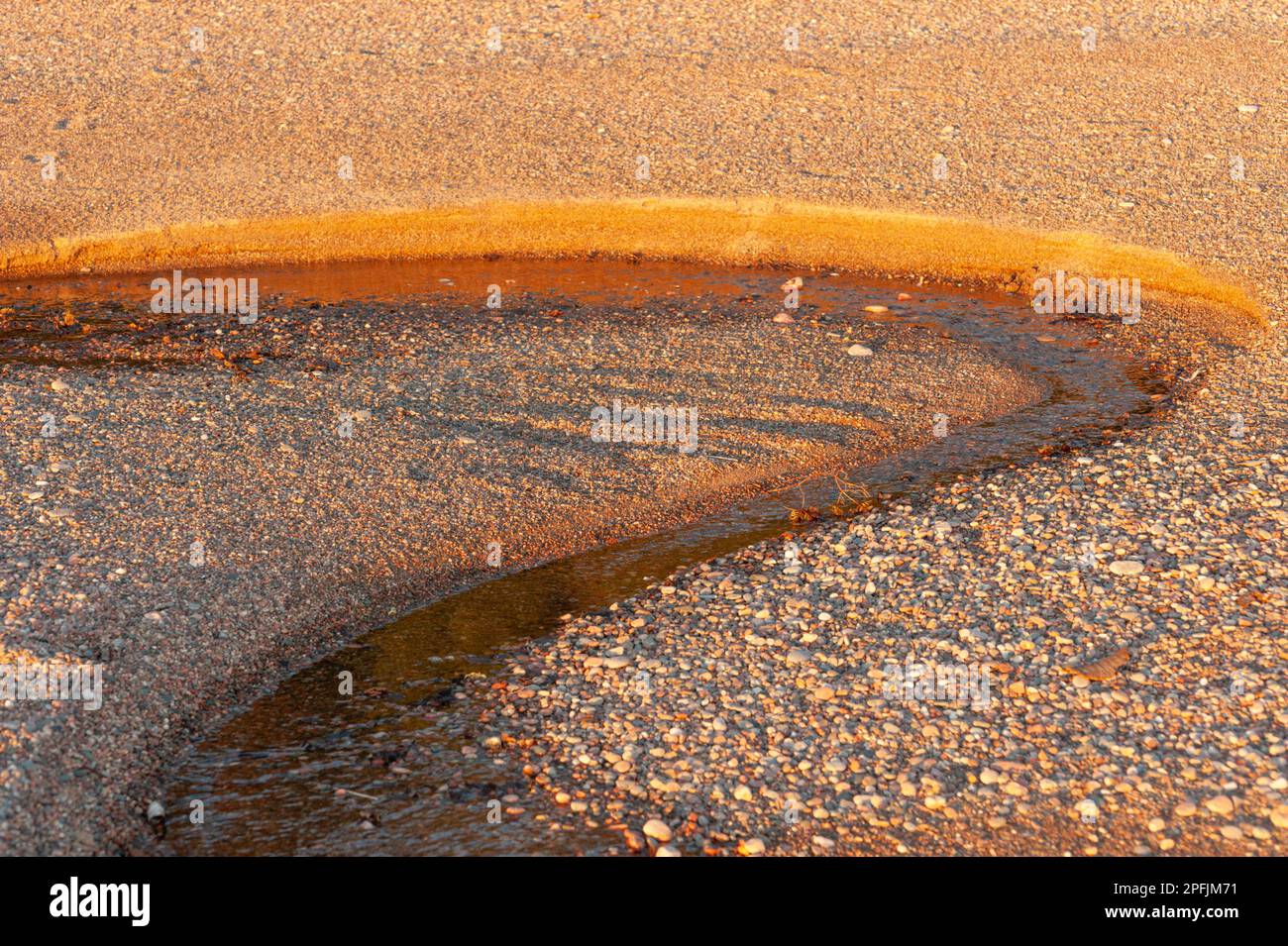 A stream winds across the pebble beach at Lake Superior Provincial Park ...