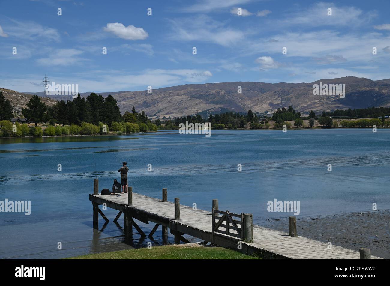 Two people fishing from a jetty at Lake Dunstan, Cromwell, Central ...