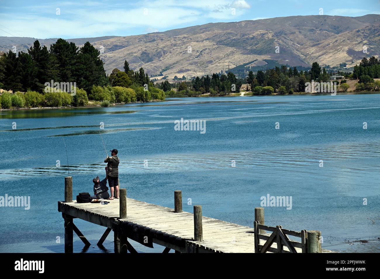 Two people fishing from a jetty at Lake Dunstan, Cromwell, Central ...