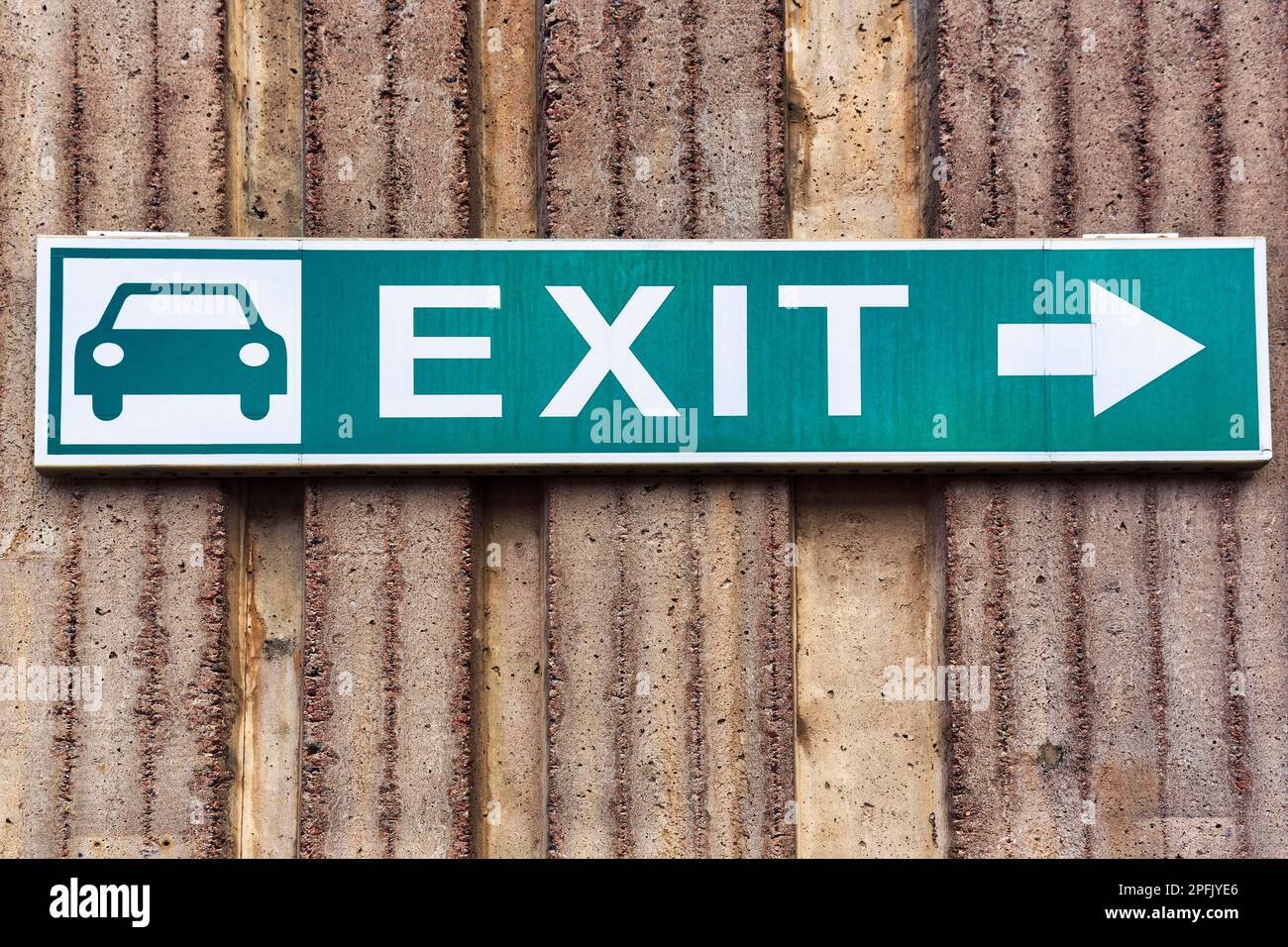 Green sign on concrete wall, signpost with pictogram car, inscription ...