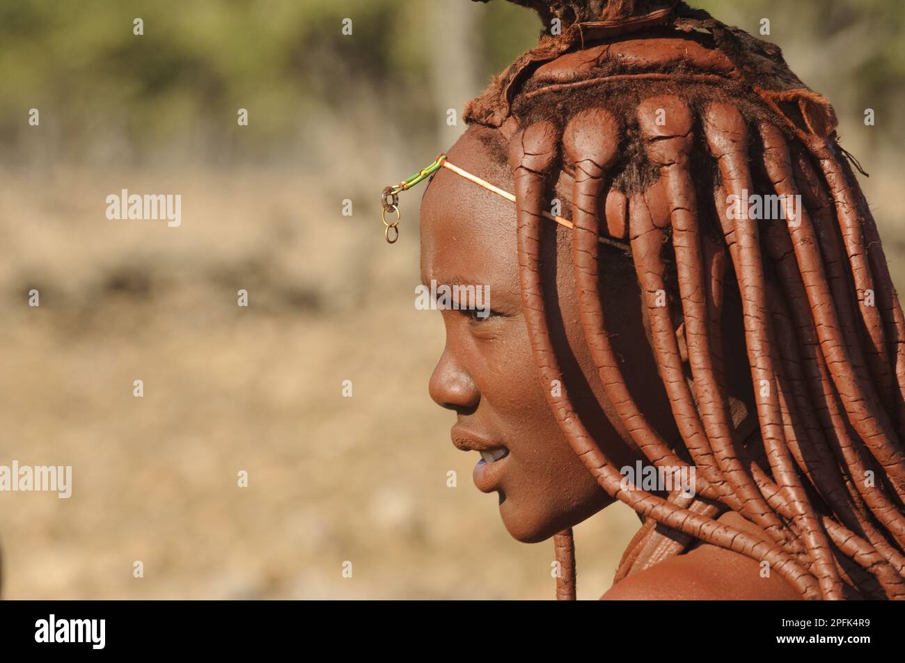 Himba girl with traditional ochre braid hairstyle, close-up of head ...