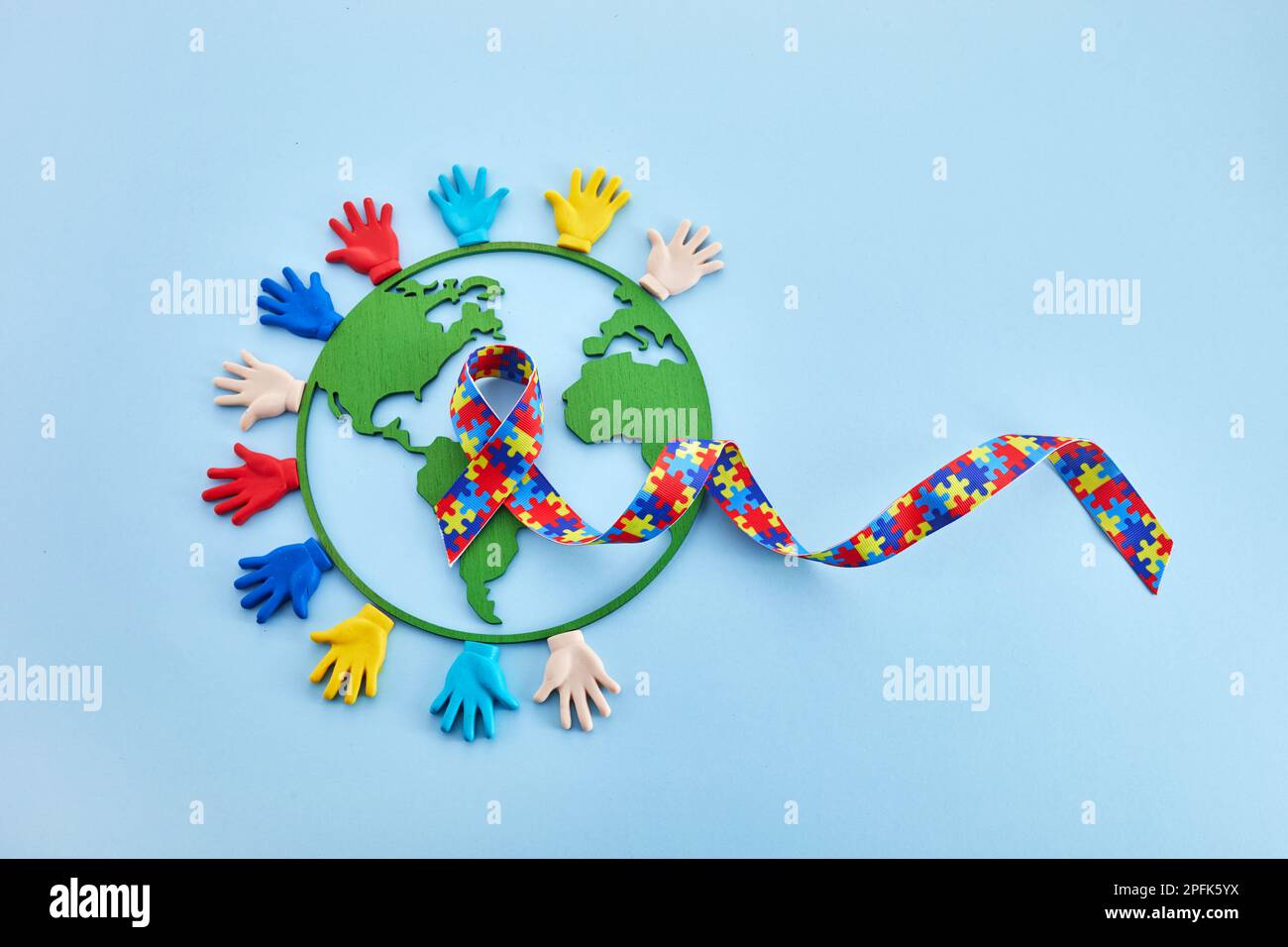 Hands and puzzle ribbon for World Autism Awareness Day Stock Photo - Alamy