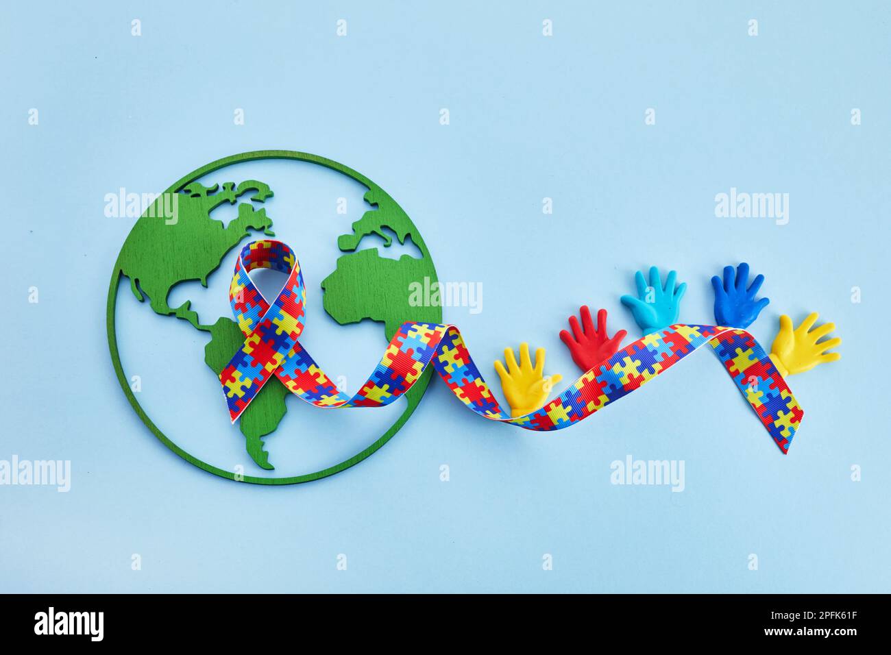 Hands and puzzle ribbon for World Autism Awareness Day Stock Photo - Alamy