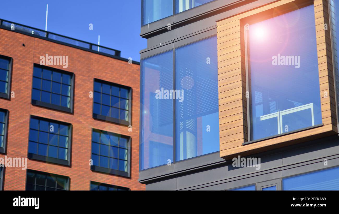 A modern corporate building in the city. The blue sky is reflected in the buildings large glass ...