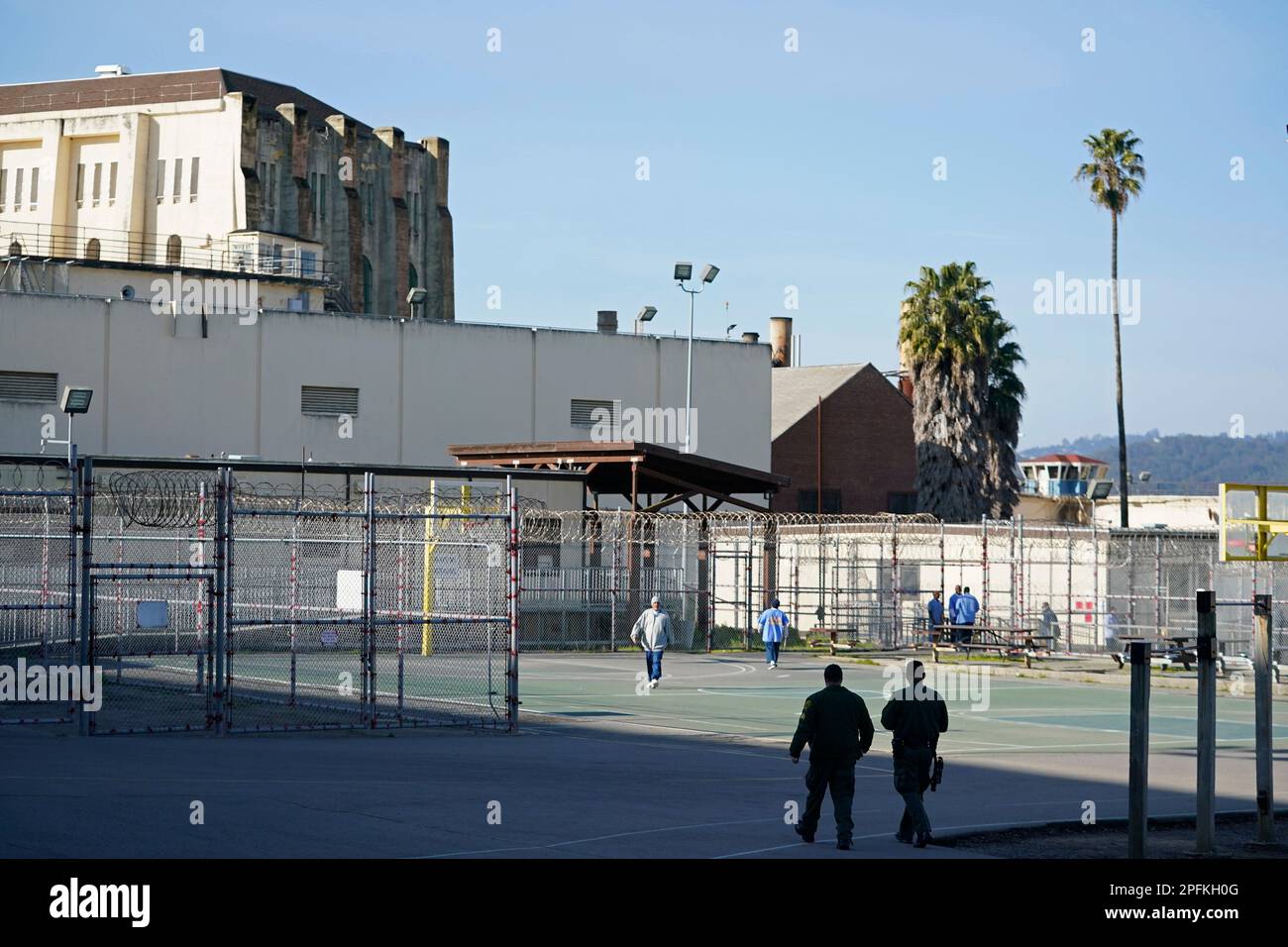 A pair of correctional officers walk through the exercise yard at San ...