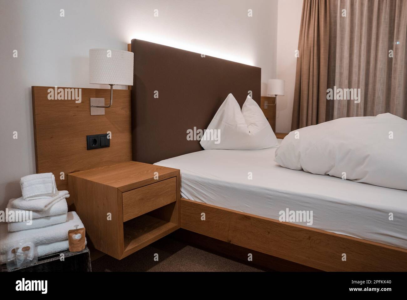 Interior of illuminated room in luxury hotel with bed and night table ...