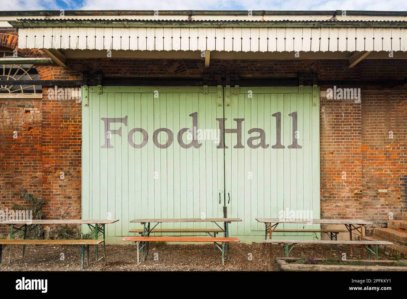 Exterior of rustic food hall building with large wooden barn doors and ...