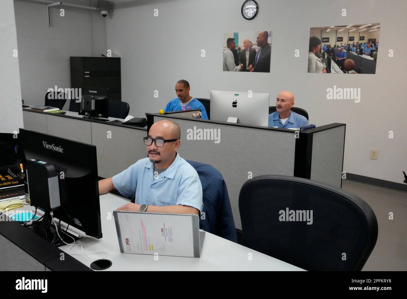 Incarcerated men including Khiem Tran, foreground, work in the coding center at San Quentin ...