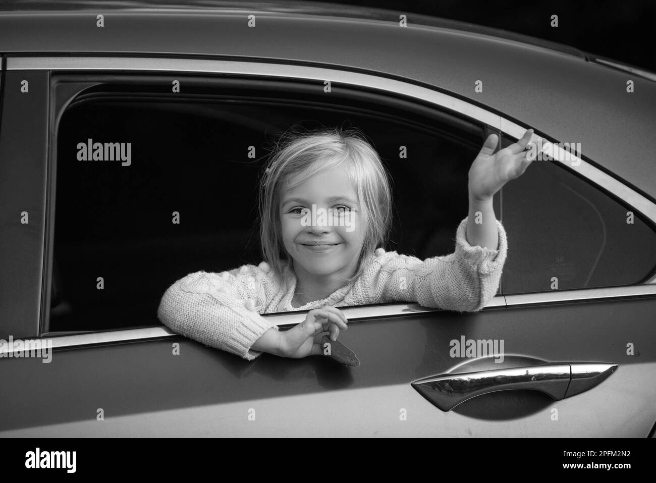 Cute little girl traveling in the car and observing nature from open ...