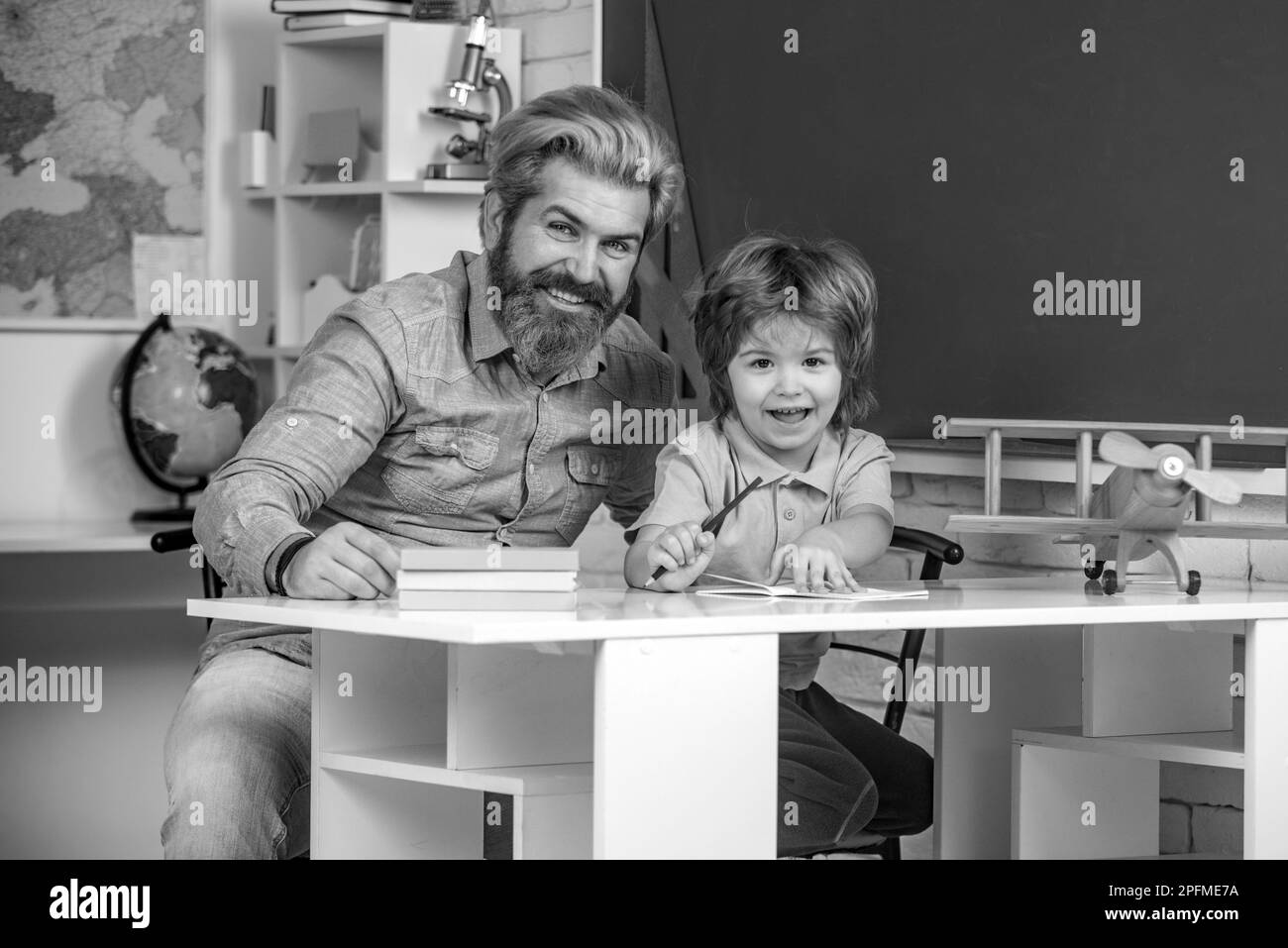 Elementary school tutor. Teacher and pupil in classroom. Pupil of ...