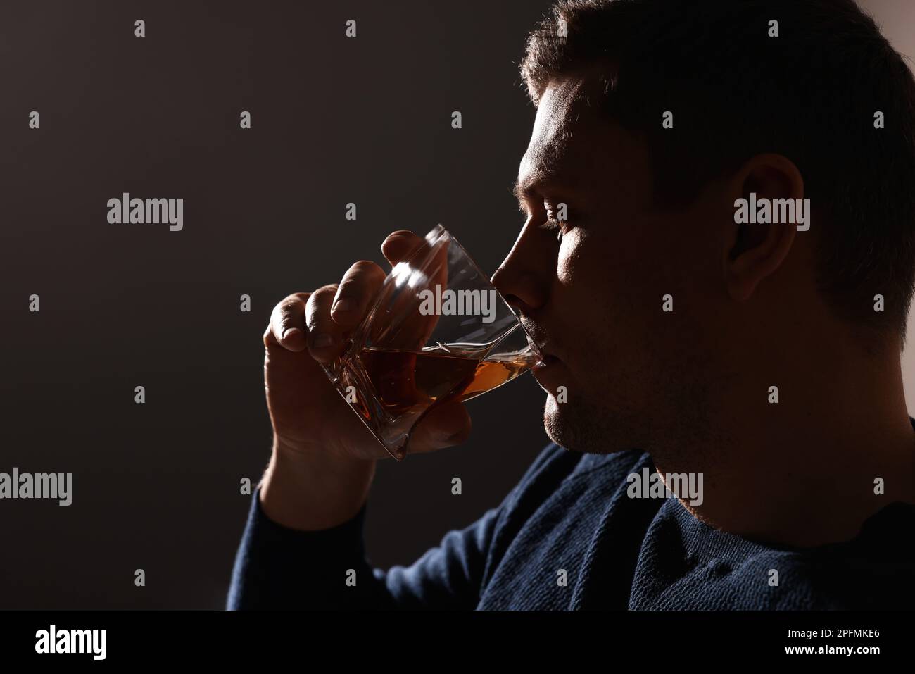 Addicted man drinking alcohol on dark background, closeup Stock Photo ...