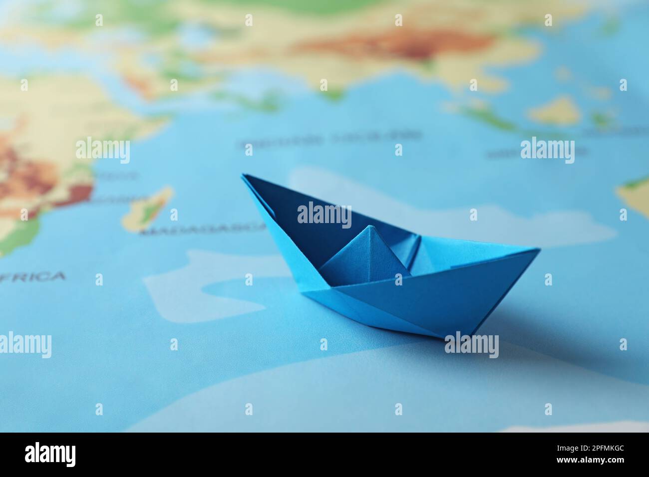 Light blue paper boat on world map, closeup Stock Photo - Alamy