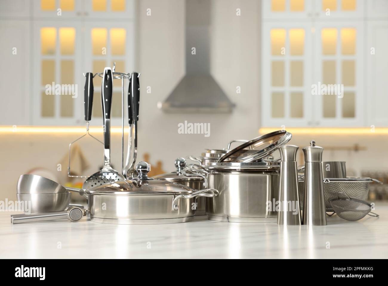Set of shiny cooking utensils on table in kitchen Stock Photo - Alamy