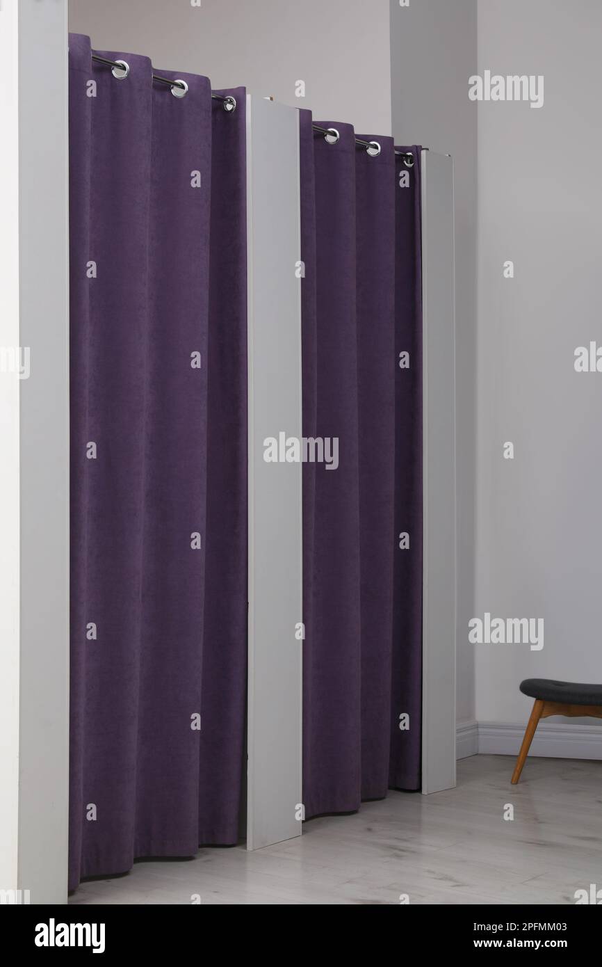 Dressing rooms with stylish purple curtains in fashion store Stock ...