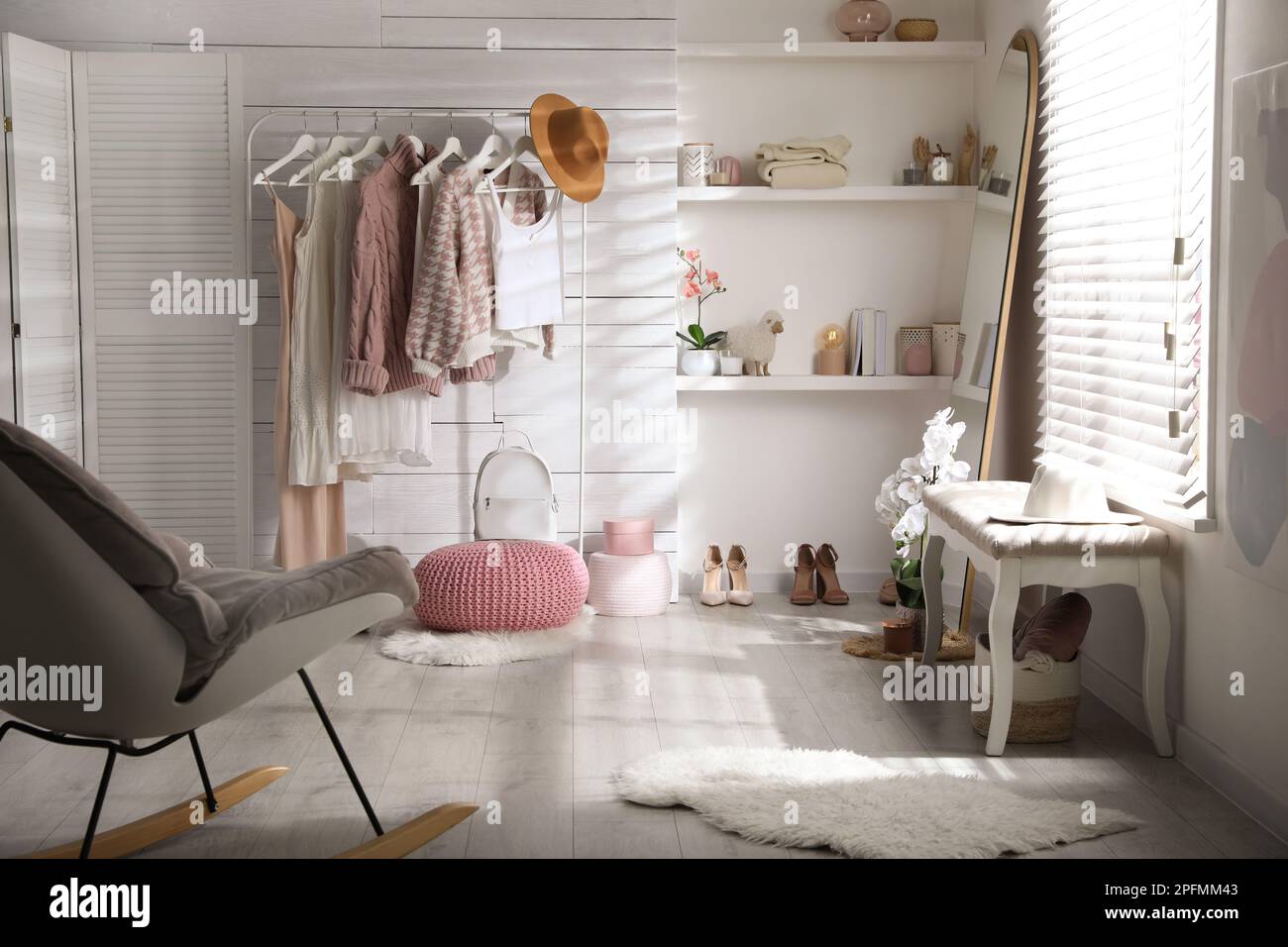 Rack with different stylish clothes, shoes and decorative elements in ...