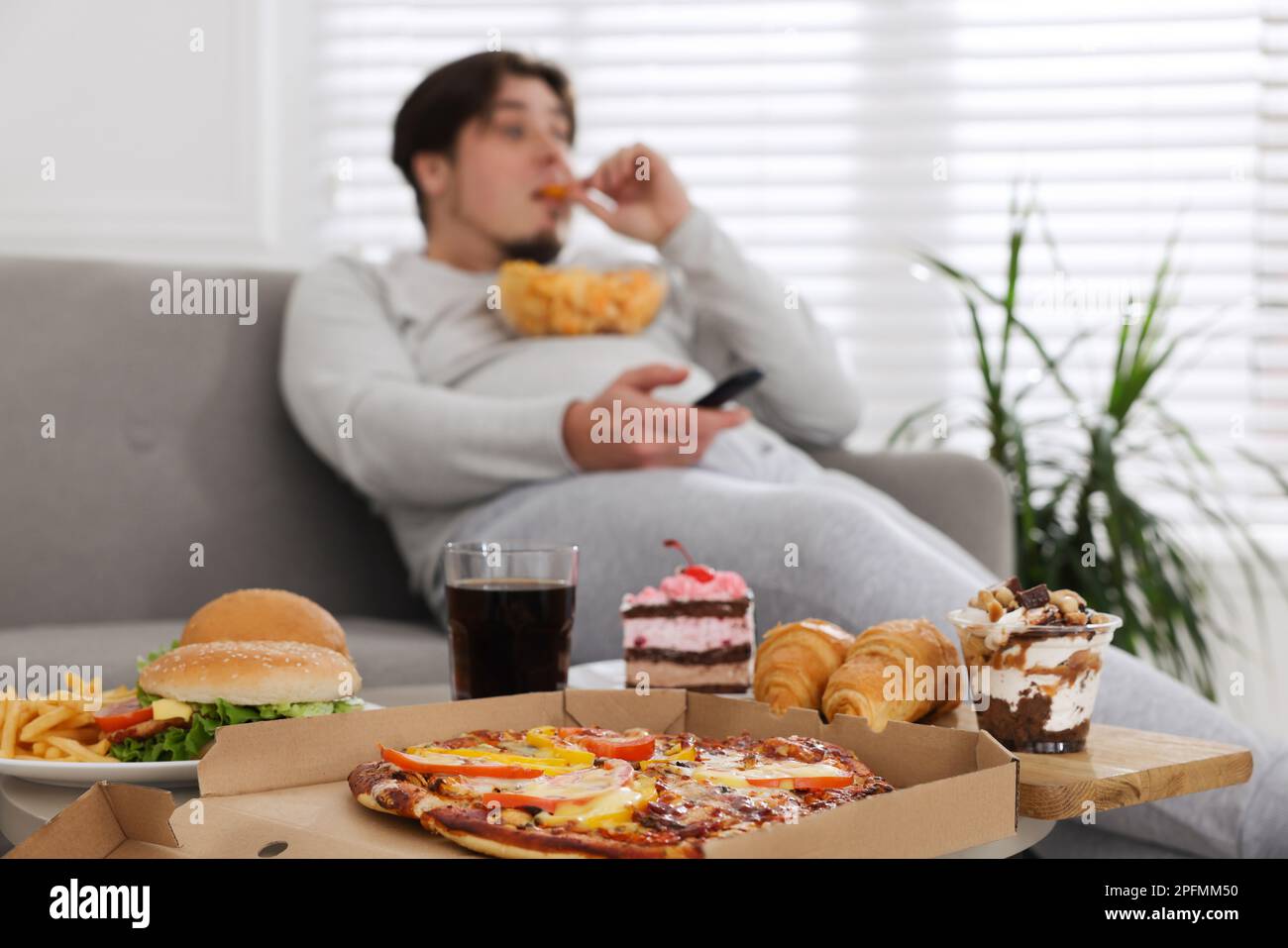 Fat man sofa junk food tv hi-res stock photography and images - Alamy
