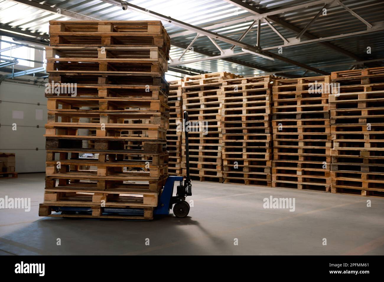 Modern manual forklift with wooden pallets in warehouse, space for text ...
