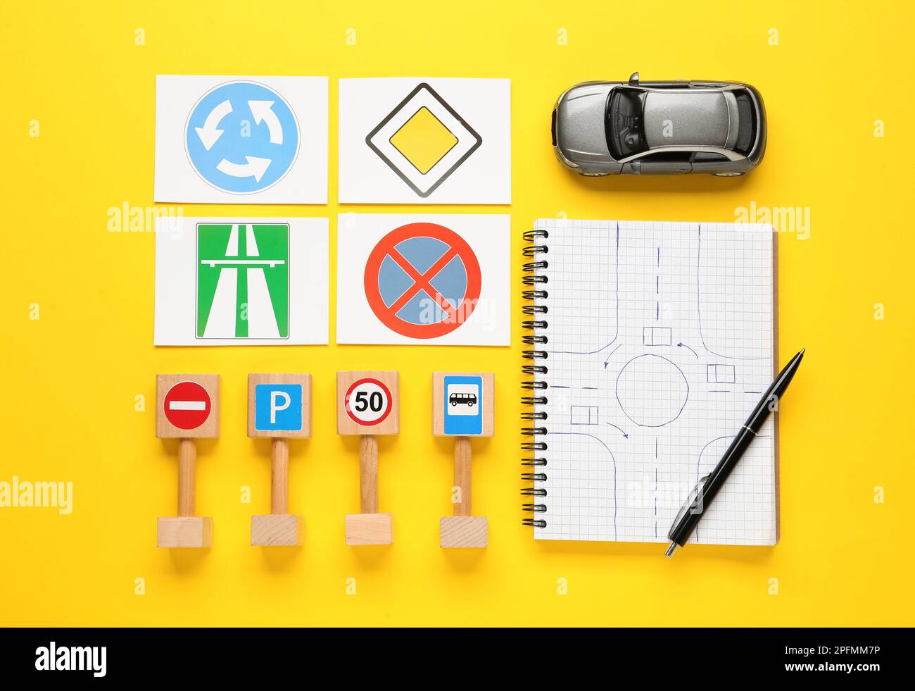 Many different road signs, notebook with sketch of roundabout and toy ...