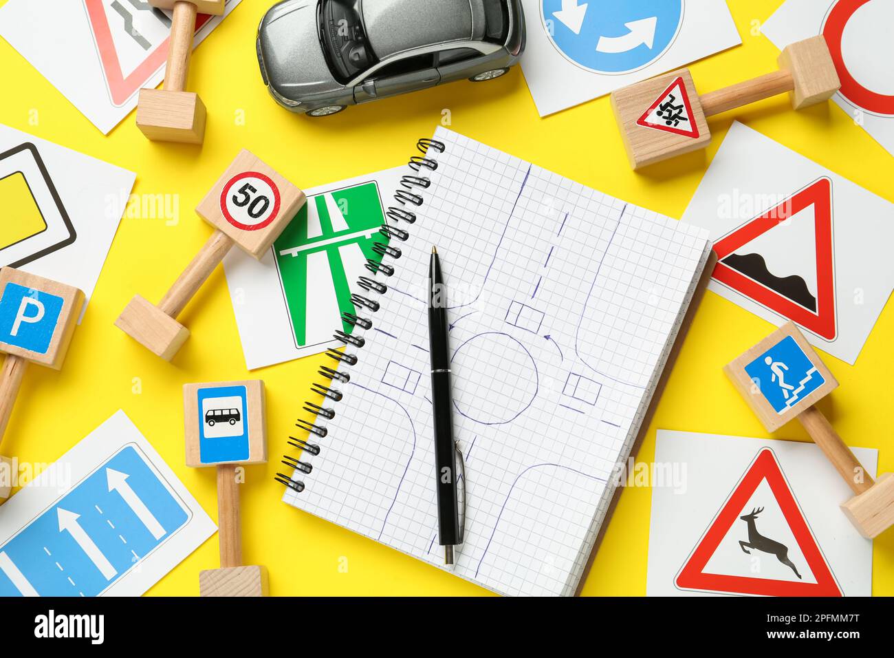 Many different road signs, notebook with sketch of roundabout and toy ...