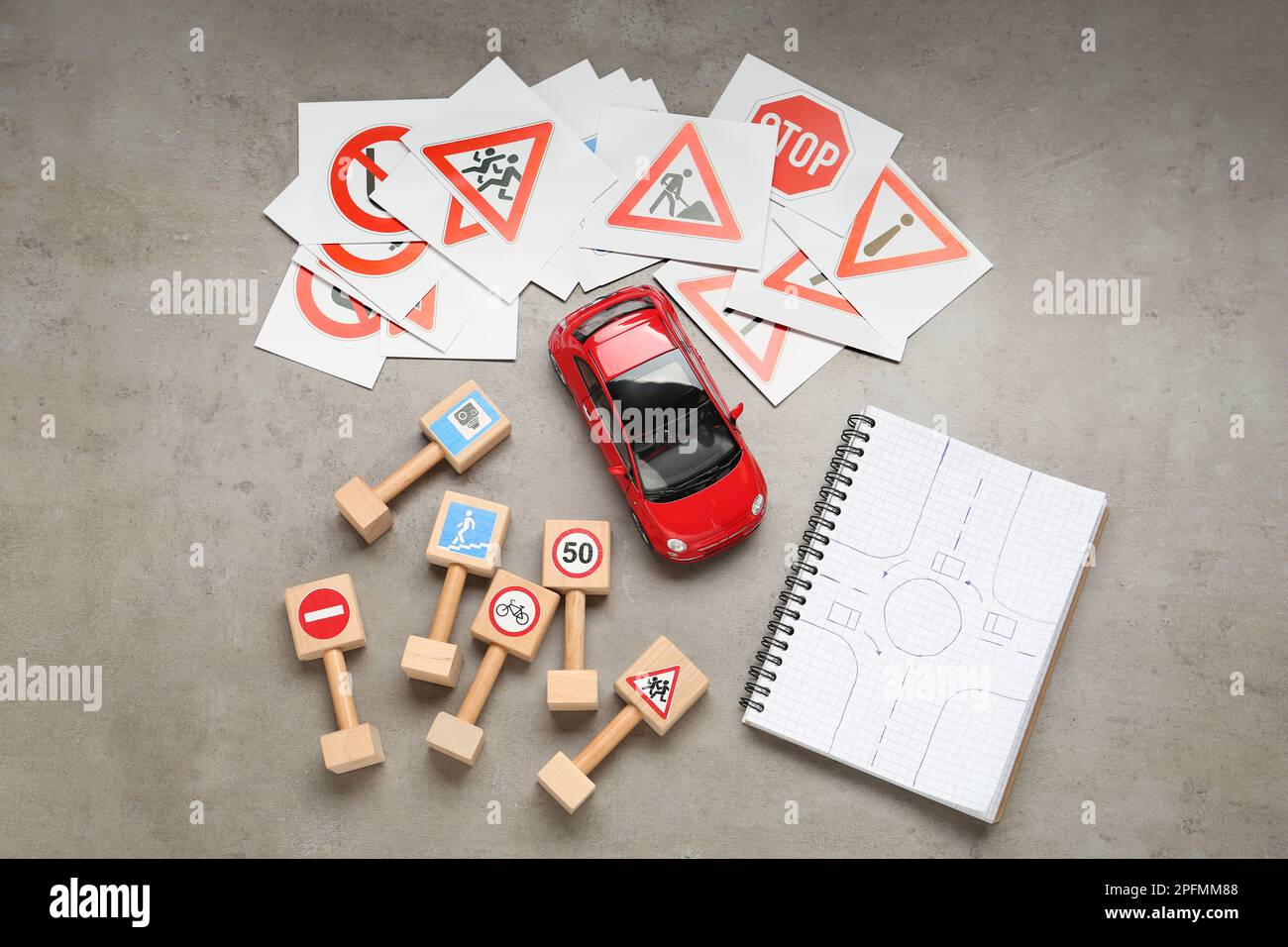 Many different road signs, notebook with sketch of roundabout and toy ...