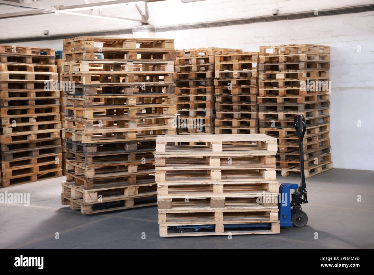 Modern manual forklift and wooden pallets in warehouse Stock Photo - Alamy