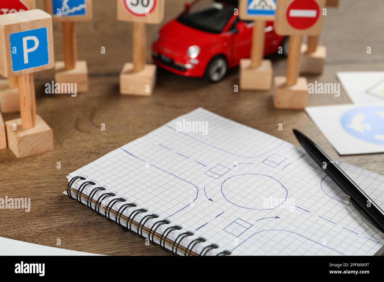 Many different road signs, notebook with sketch of roundabout and toy ...