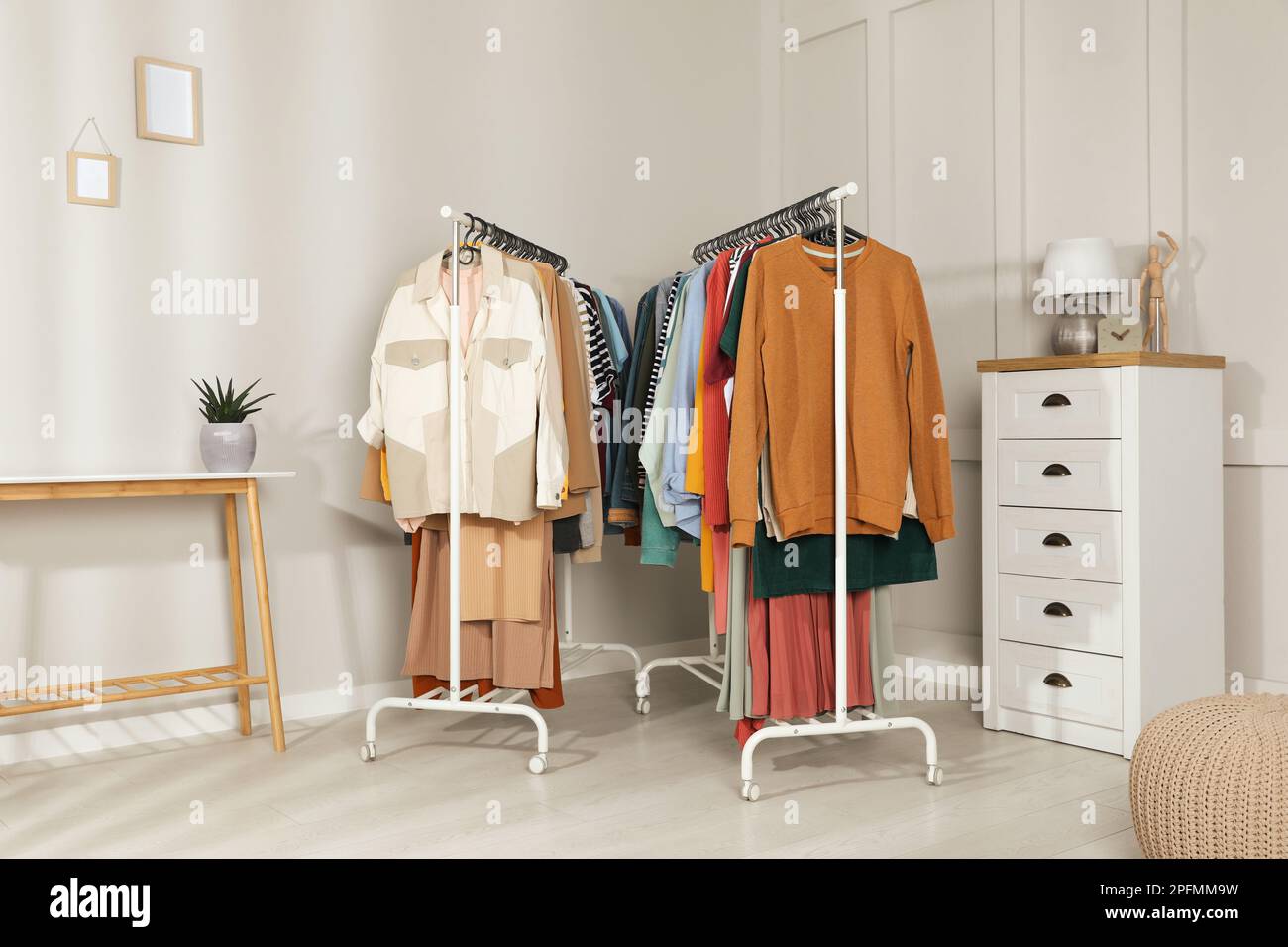 Racks with stylish clothes in cozy room interior. Fast fashion Stock ...