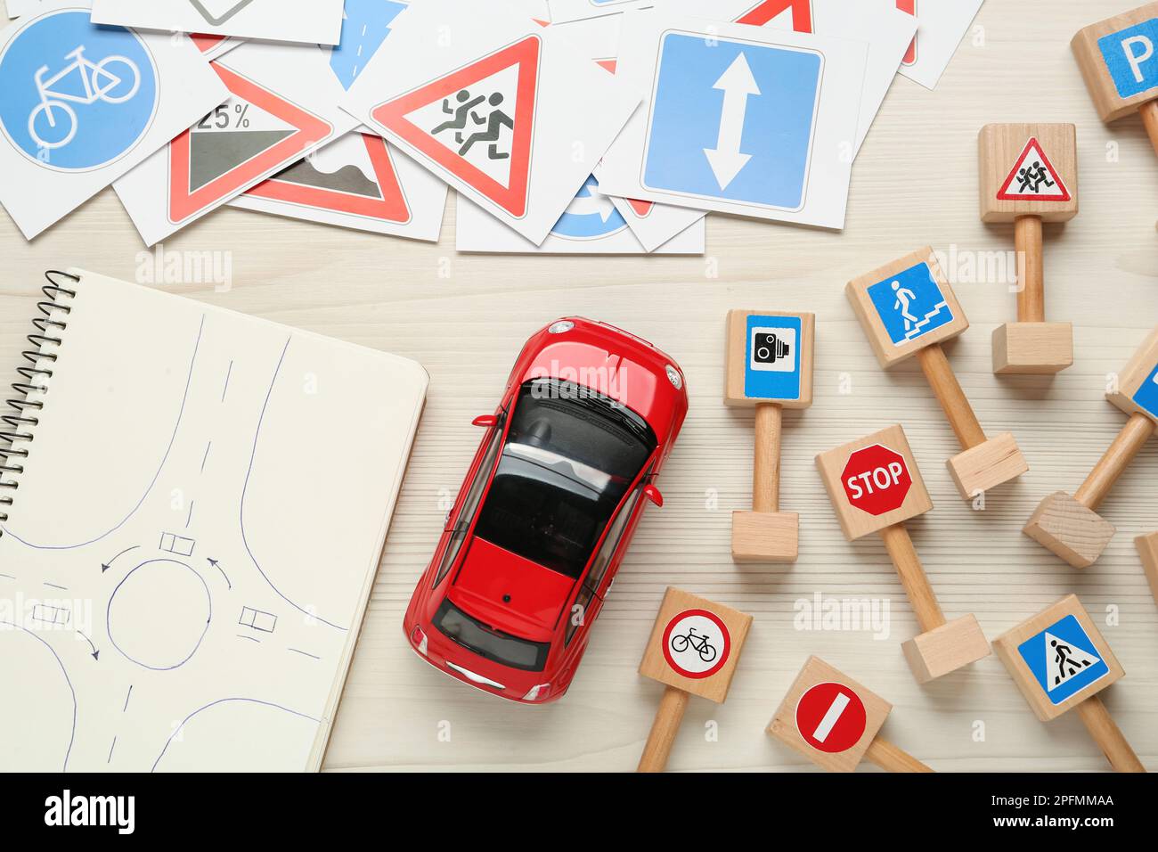 Many different road signs, notebook with sketch of roundabout and toy ...