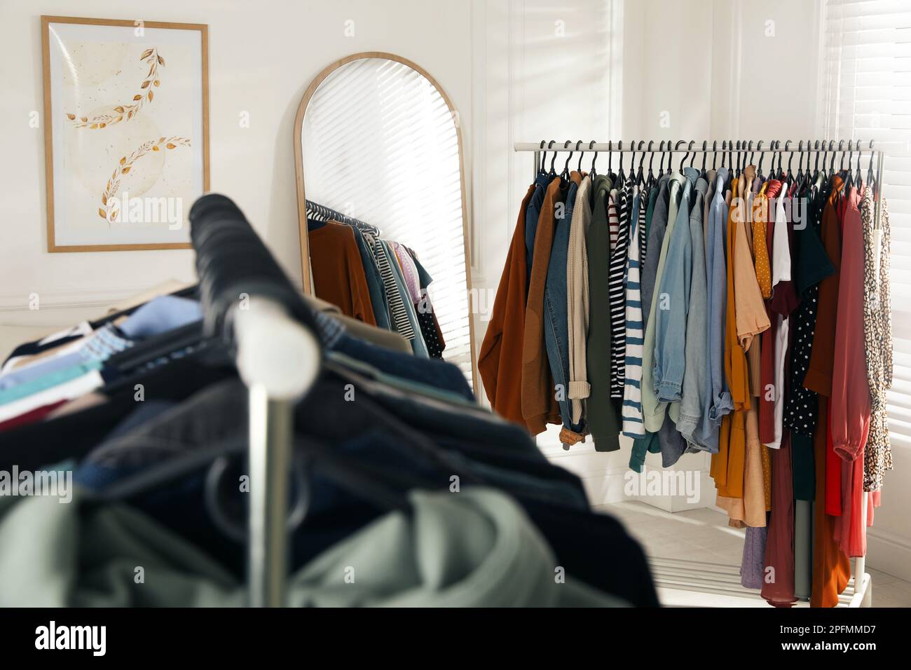 Racks with stylish clothes indoors. Fast fashion Stock Photo - Alamy
