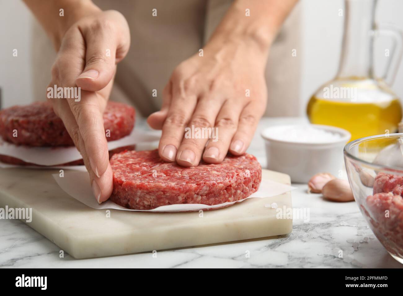 Woman making hamburger patties at white marble table, closeup Stock ...