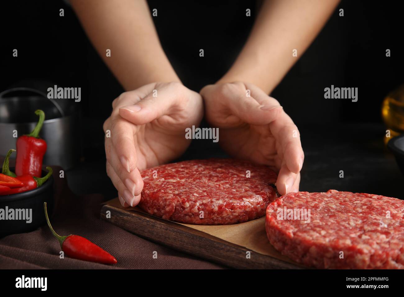 Woman making hamburger patties at wooden table, closeup Stock Photo - Alamy