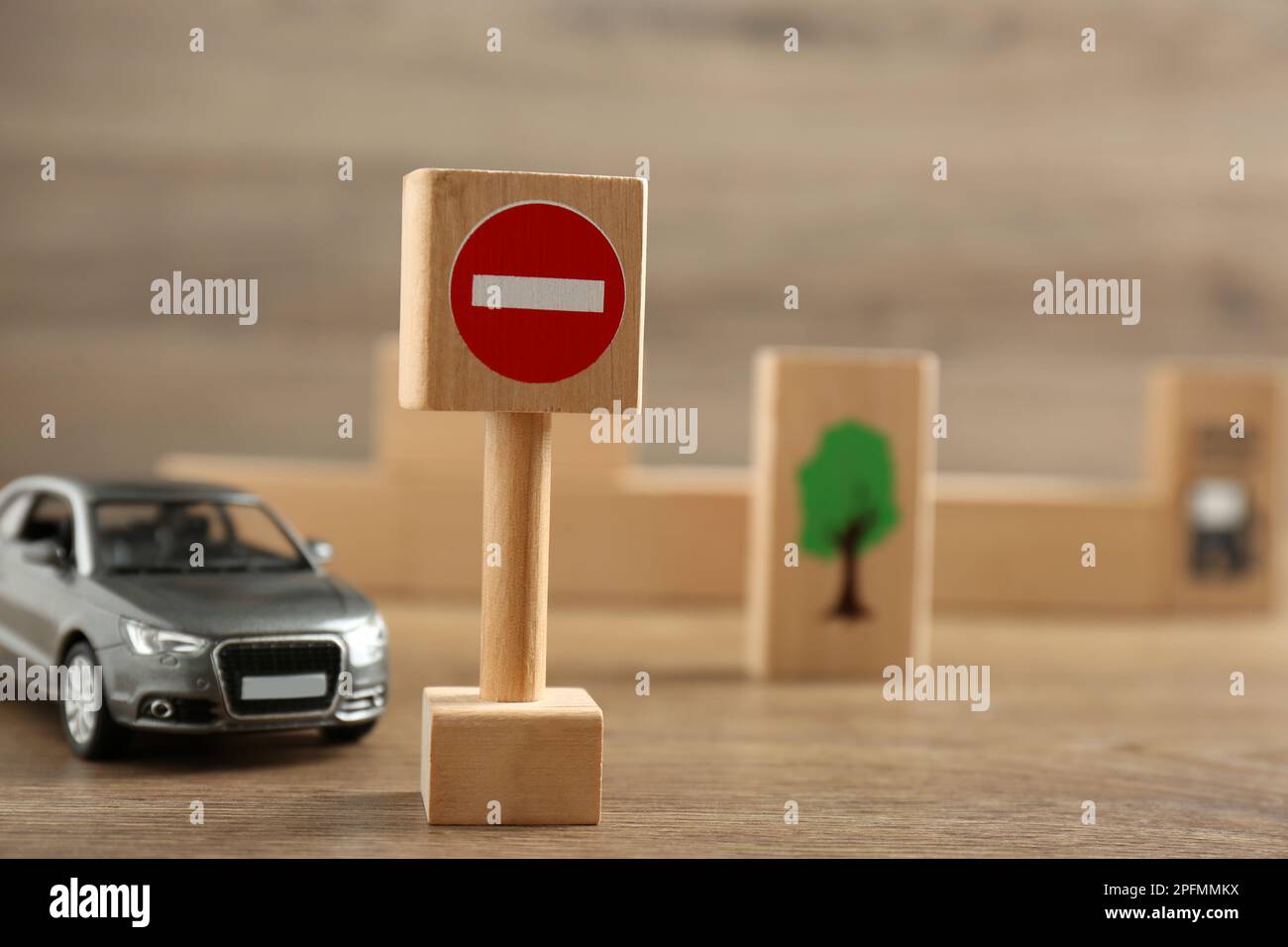 Traffic sign No entry and toy car on wooden table. Passing driving ...