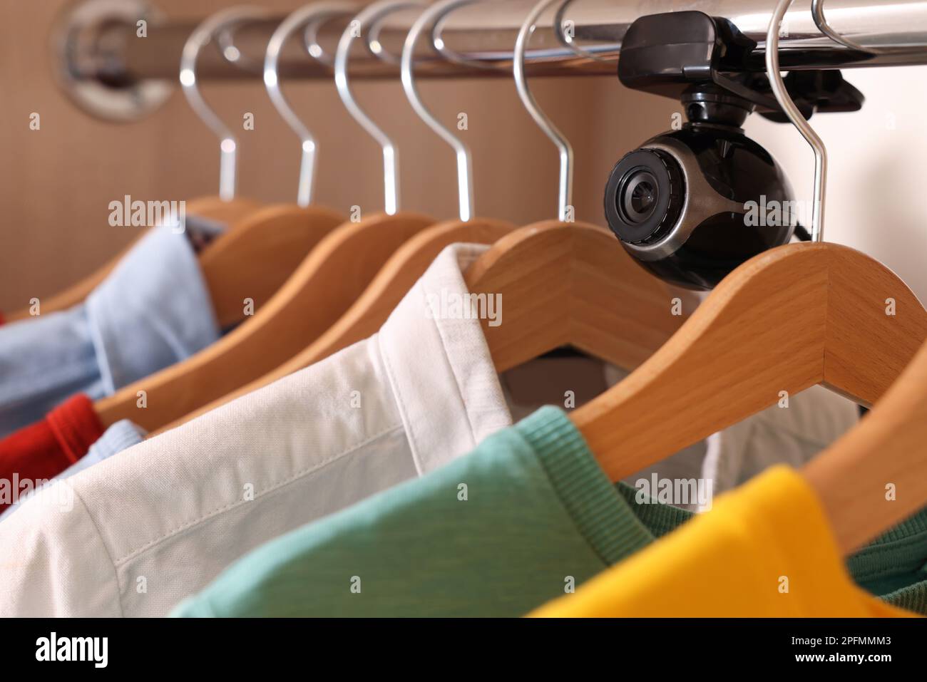 Camera hidden between hangers in wardrobe closet, closeup Stock Photo ...