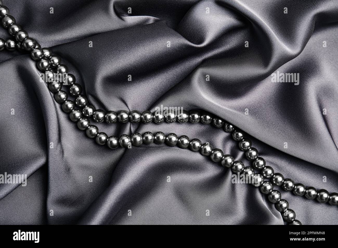 Beautiful pearls on grey silk, top view Stock Photo - Alamy