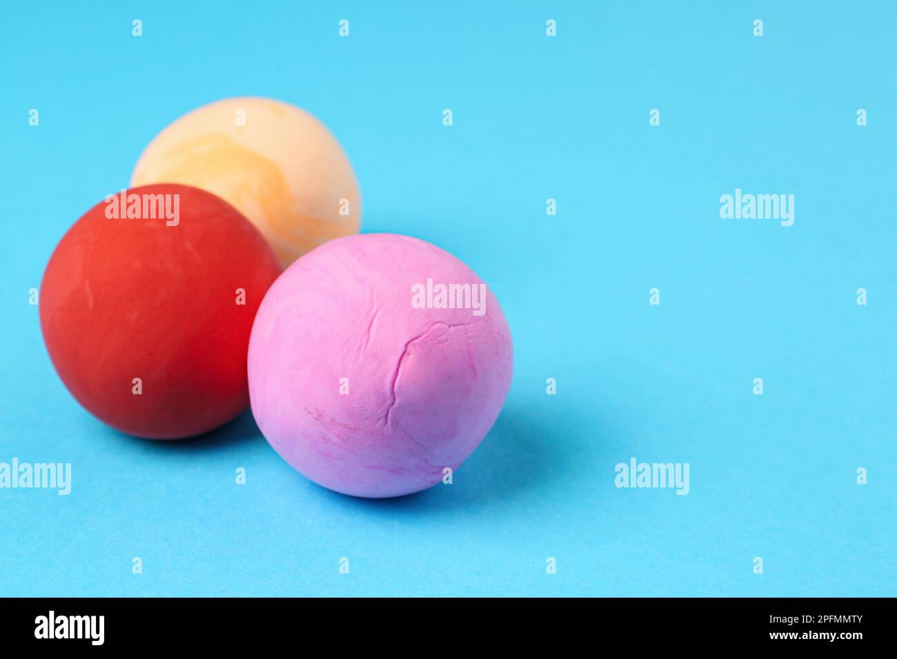Different color play dough balls on light blue background, closeup. Space for text Stock Photo ...