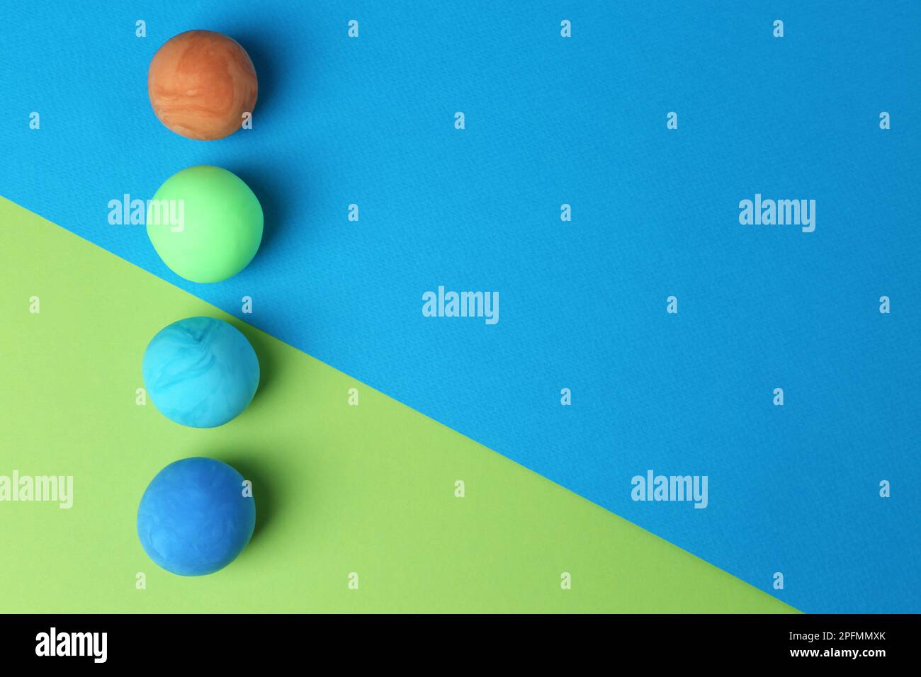 Different bright play dough on color background, flat lay. Space for ...