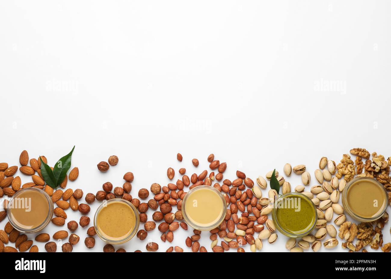 Different types of delicious nut butters and ingredients on white ...